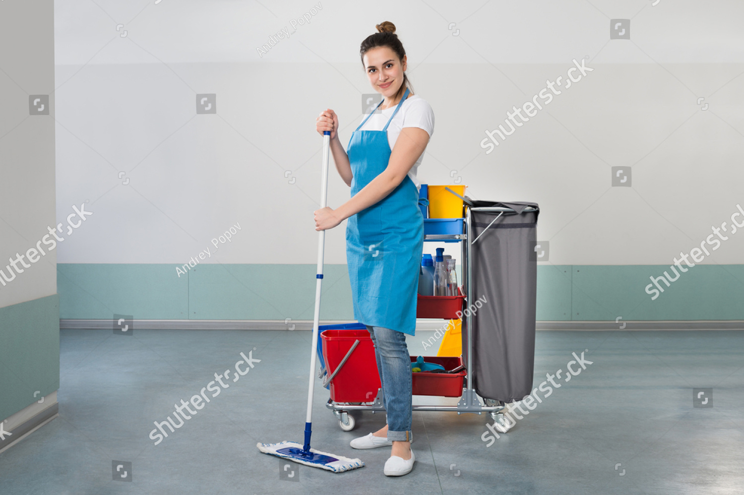stock-photo-happy-young-female-janitor-with-cleaning-equipment ...